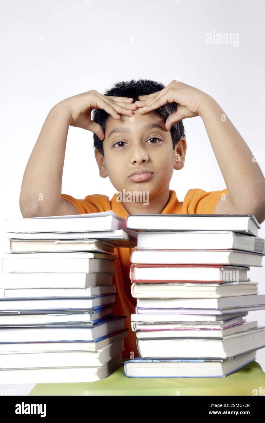 Boy in tension standing with stack of books MR#152 Stock Photo - Alamy