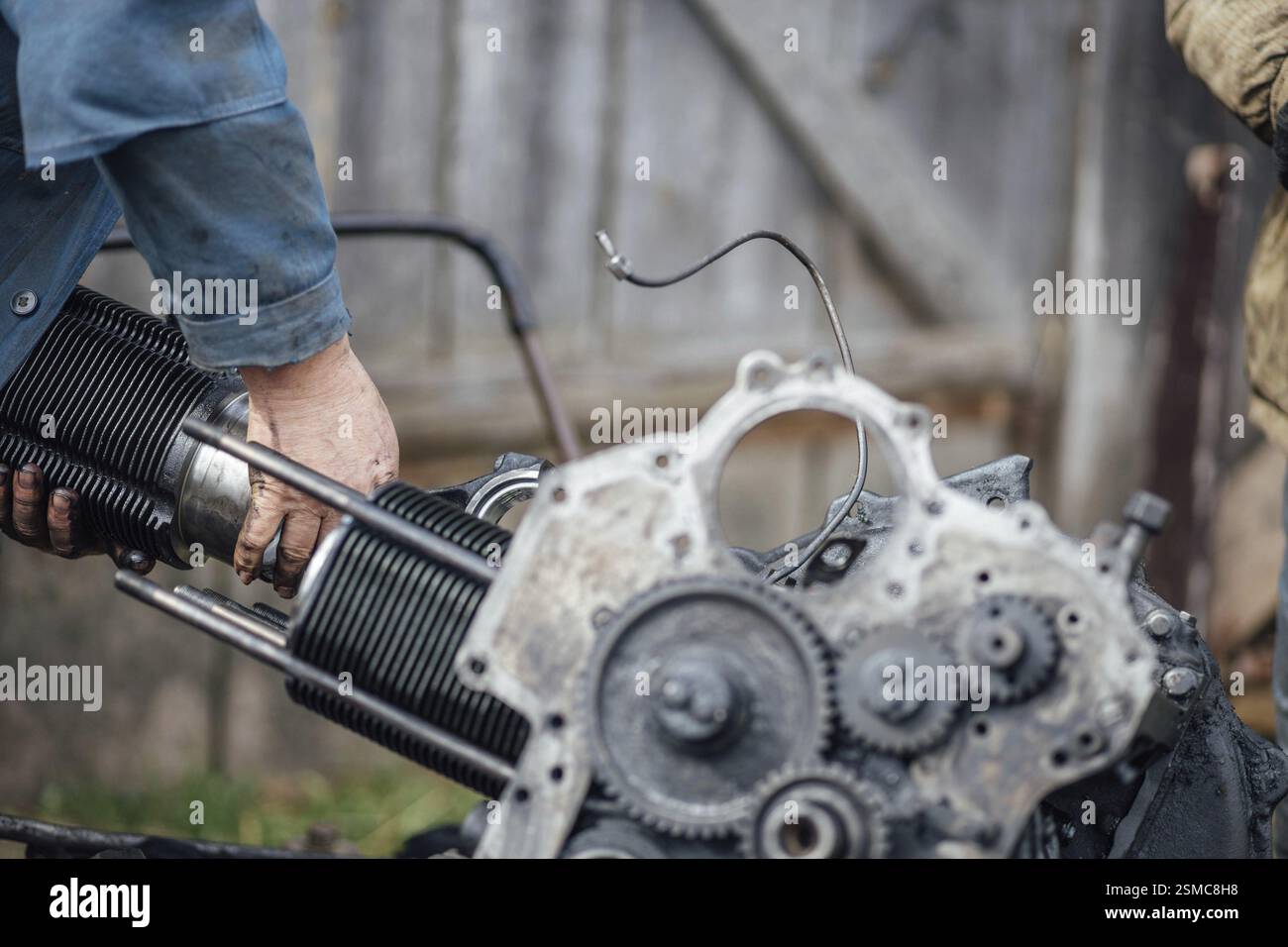 A hand working on repairing an engine outdoors with exposed gears Stock ...