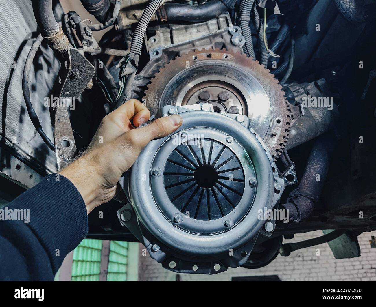 Mechanic prepares to install a clutch disk on a car engine Stock Photo ...