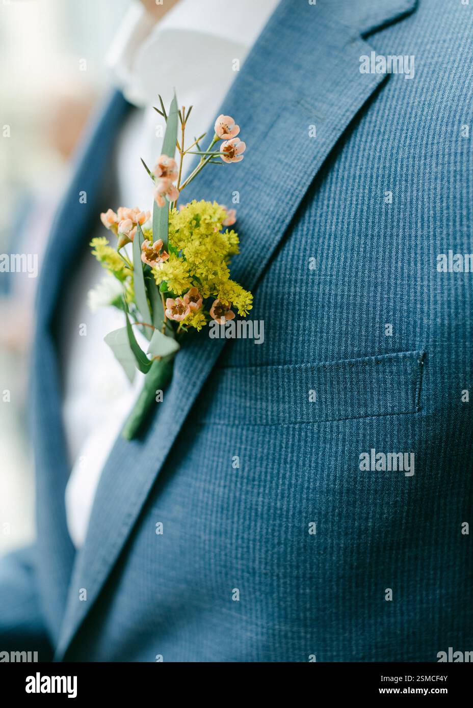 The groom sports a stylish boutonniere of soft flowers and greenery ...