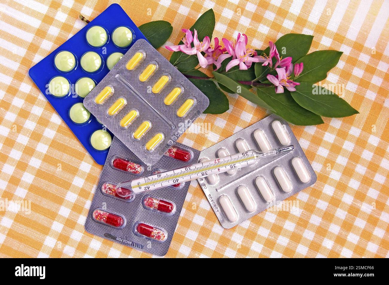 The set of tablets and capsules with a thermometer, the water in a ...