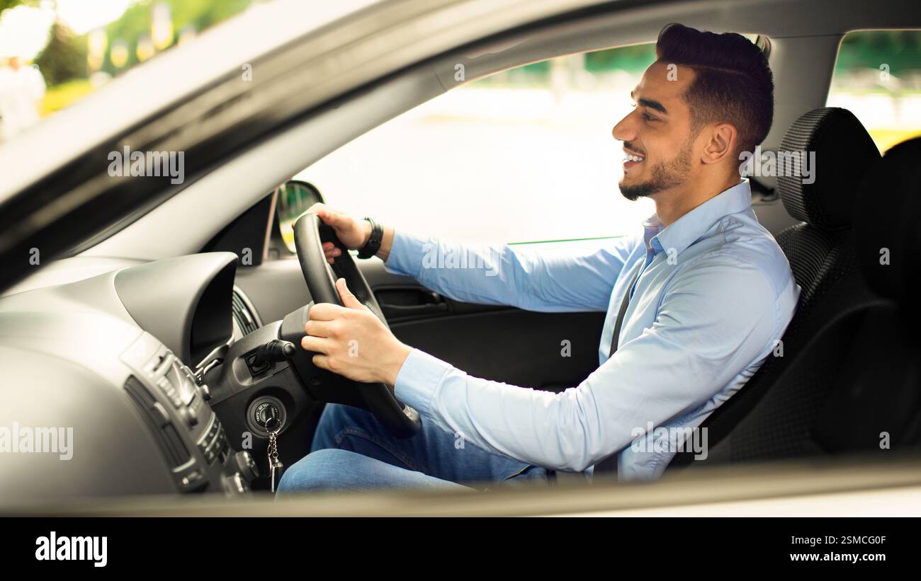 Attractive arabic guy enjoying driving, going to job Stock Photo - Alamy