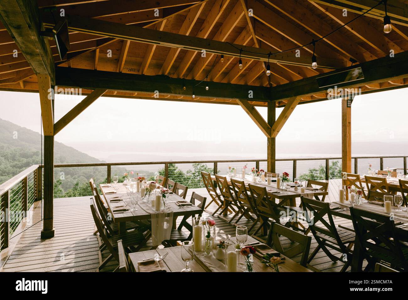 Tables are elegantly arranged for a gathering on a scenic deck ...
