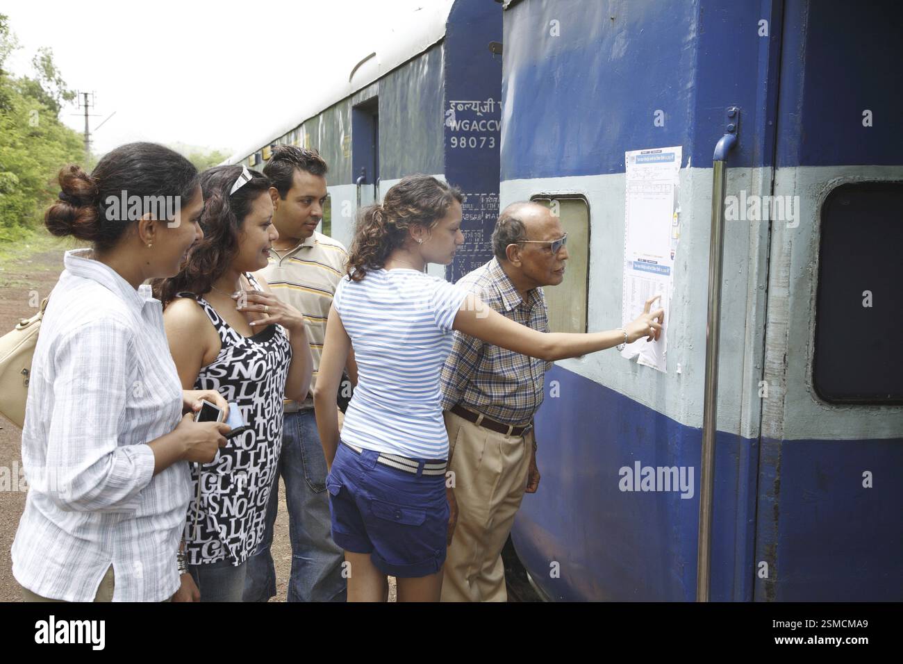 Travel group searching their names on reservation chart fixed near door ...