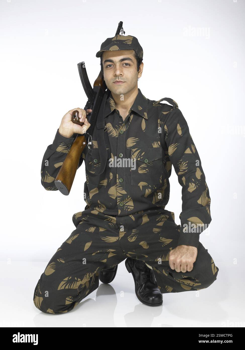 Indian army soldier sitting on knee holding AK-47 gun MR#702A Stock ...