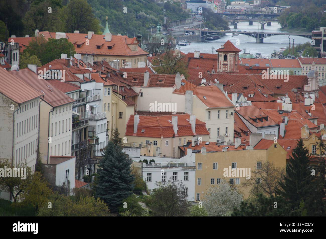 Prague cityscape. Red rooftops dominate the scene with a river and ...