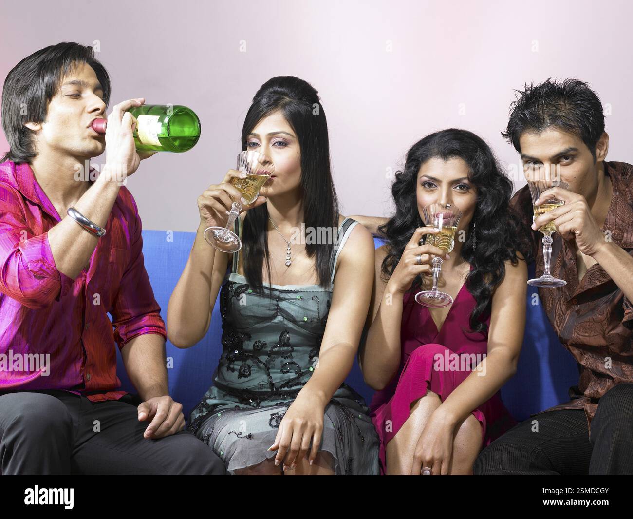 South Asian Indian men and women drinking champagne celebrating party ...