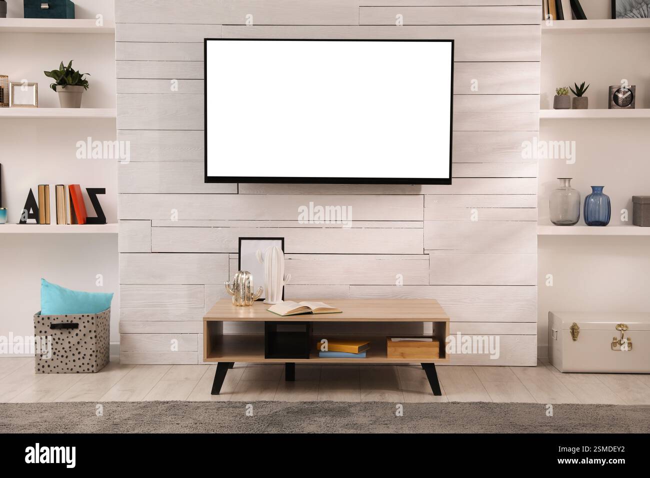 Tv set with white screen mounted on wall in room. Mockup for design ...