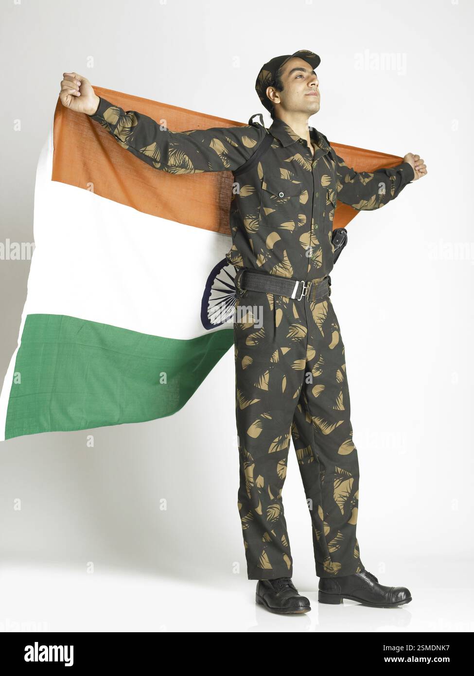 Indian army soldier standing holding flag of India on his backside MR ...