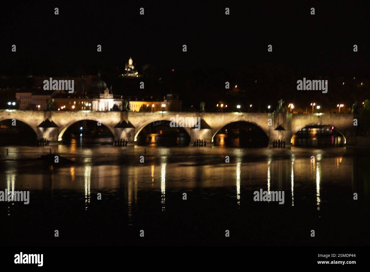 Bridge, illuminated arches spanning a river at night. Reflections shimmer in the water. Symbol ...