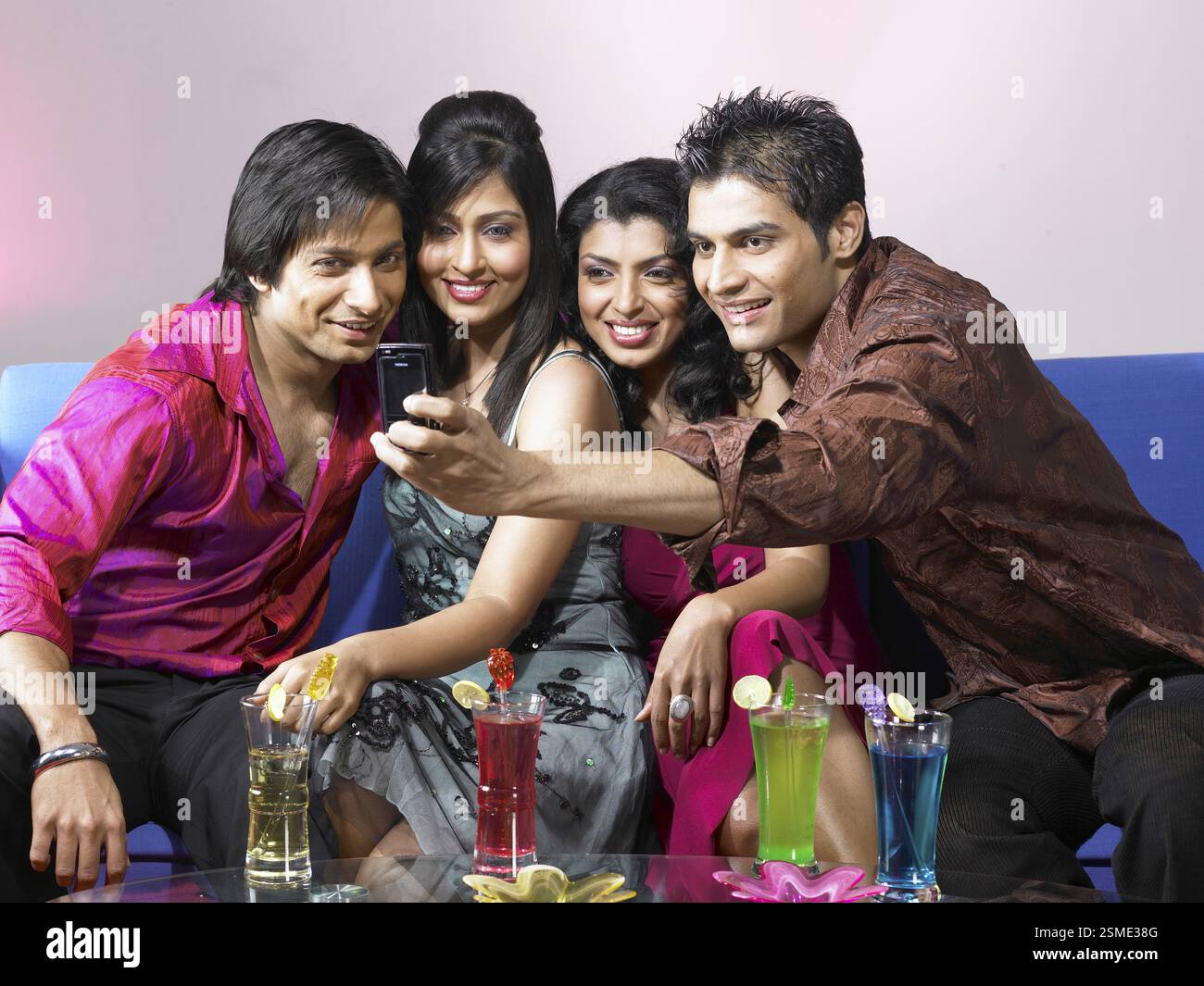 South Asian Indian man taking group photo in mobile celebrating party ...