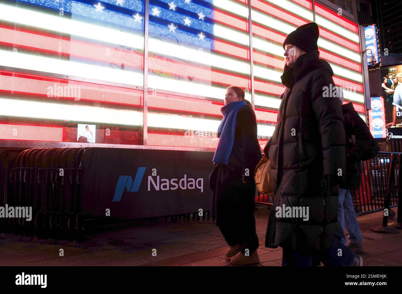 New York, United States. 11th Feb, 2025. People walk past a Nasdaq sign ...
