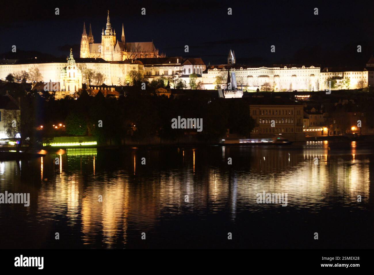 Prague Castle, a majestic complex illuminated at night, reflecting on ...