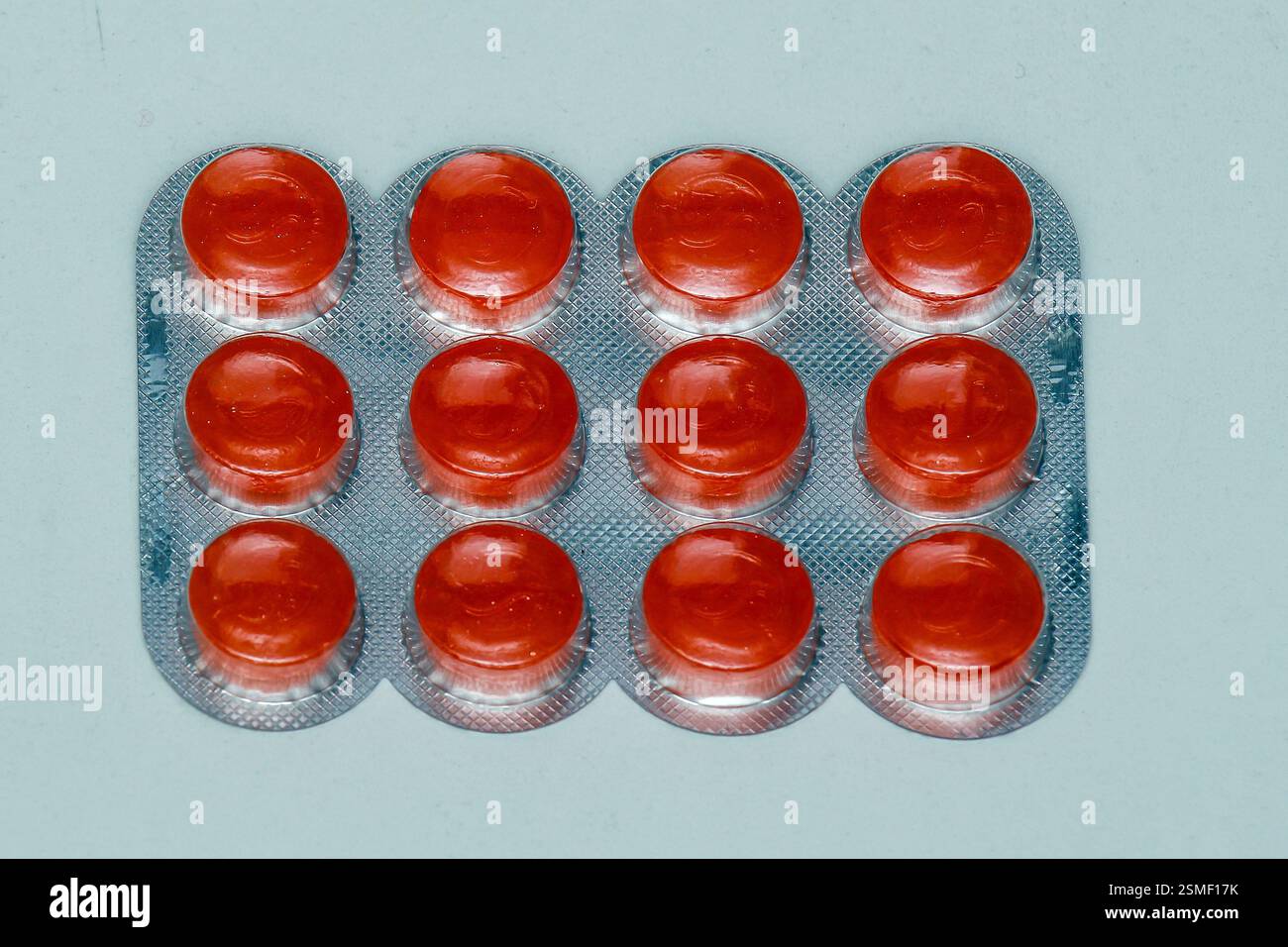 Orange throat lozenges in silver foil isolated on white Stock Photo - Alamy