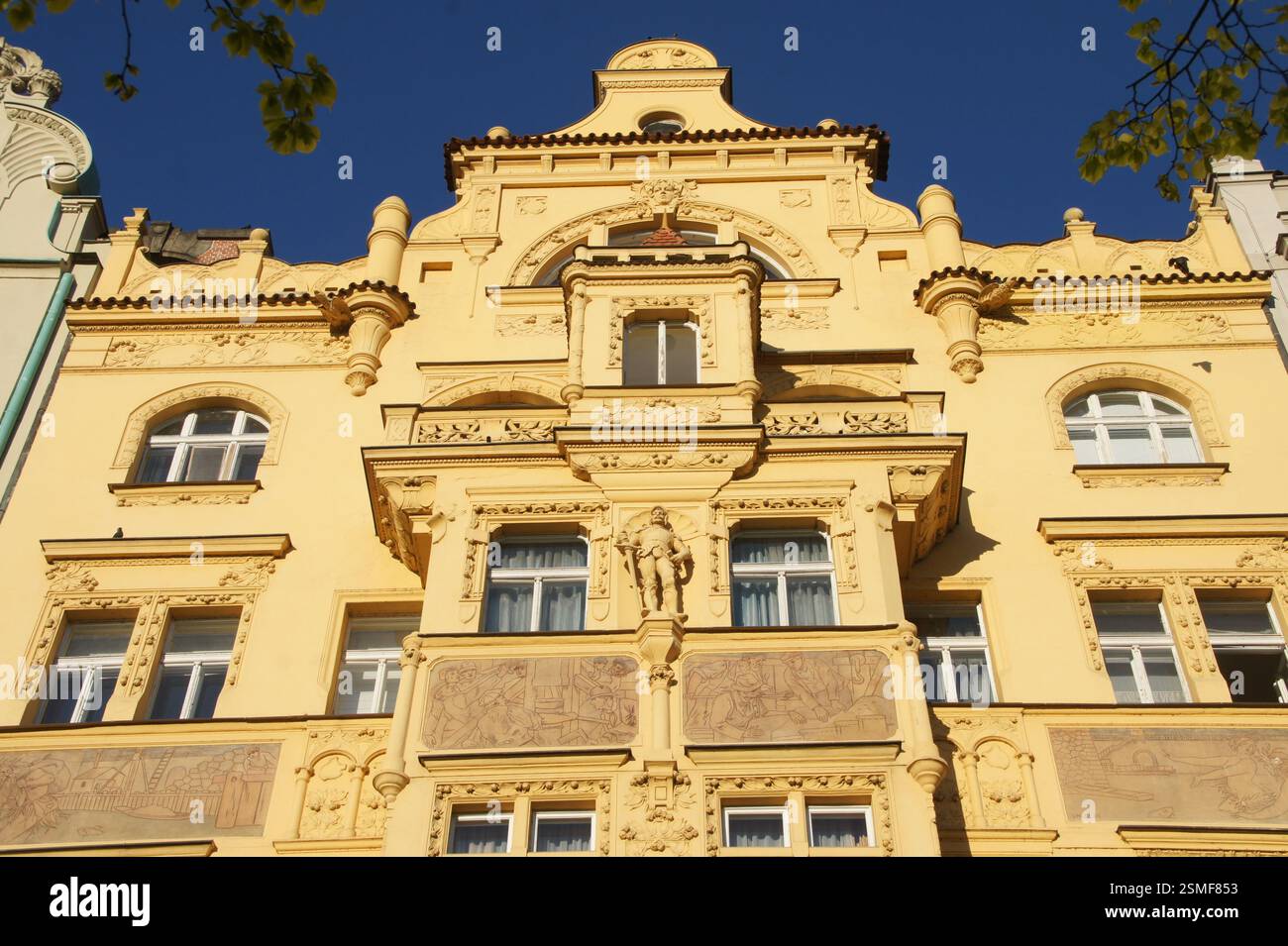 Facade. Yellow stucco building with ornate balconies and sculptures ...