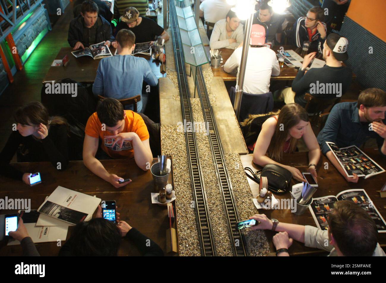 Model train on tracks beside bar. Red and black train with open brown ...