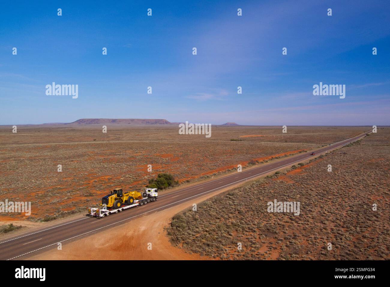 Aerial of front end loader on low loader heavy haulage truck on the ...