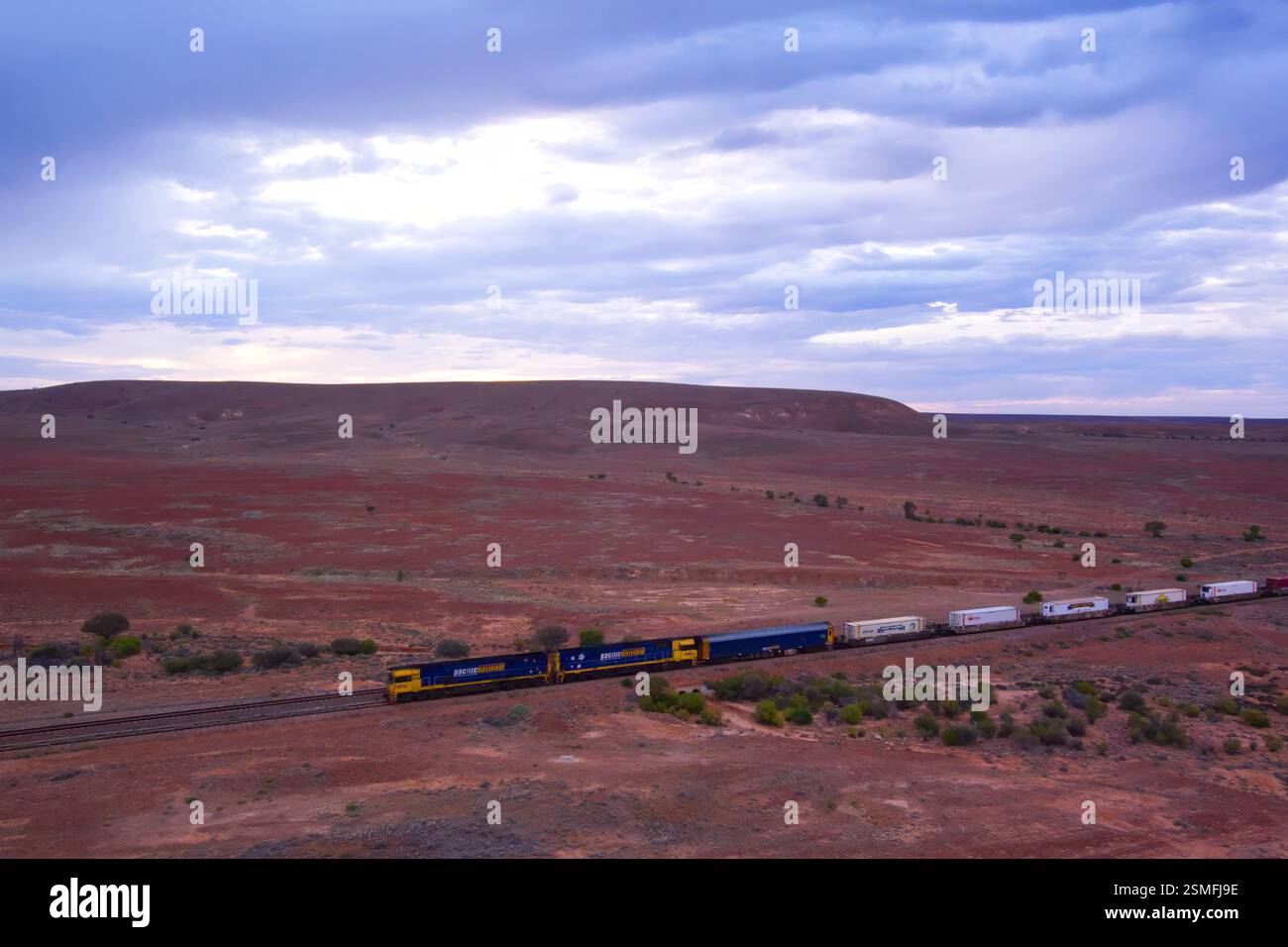 A freight train, composed of multiple double stacked containers, is ...
