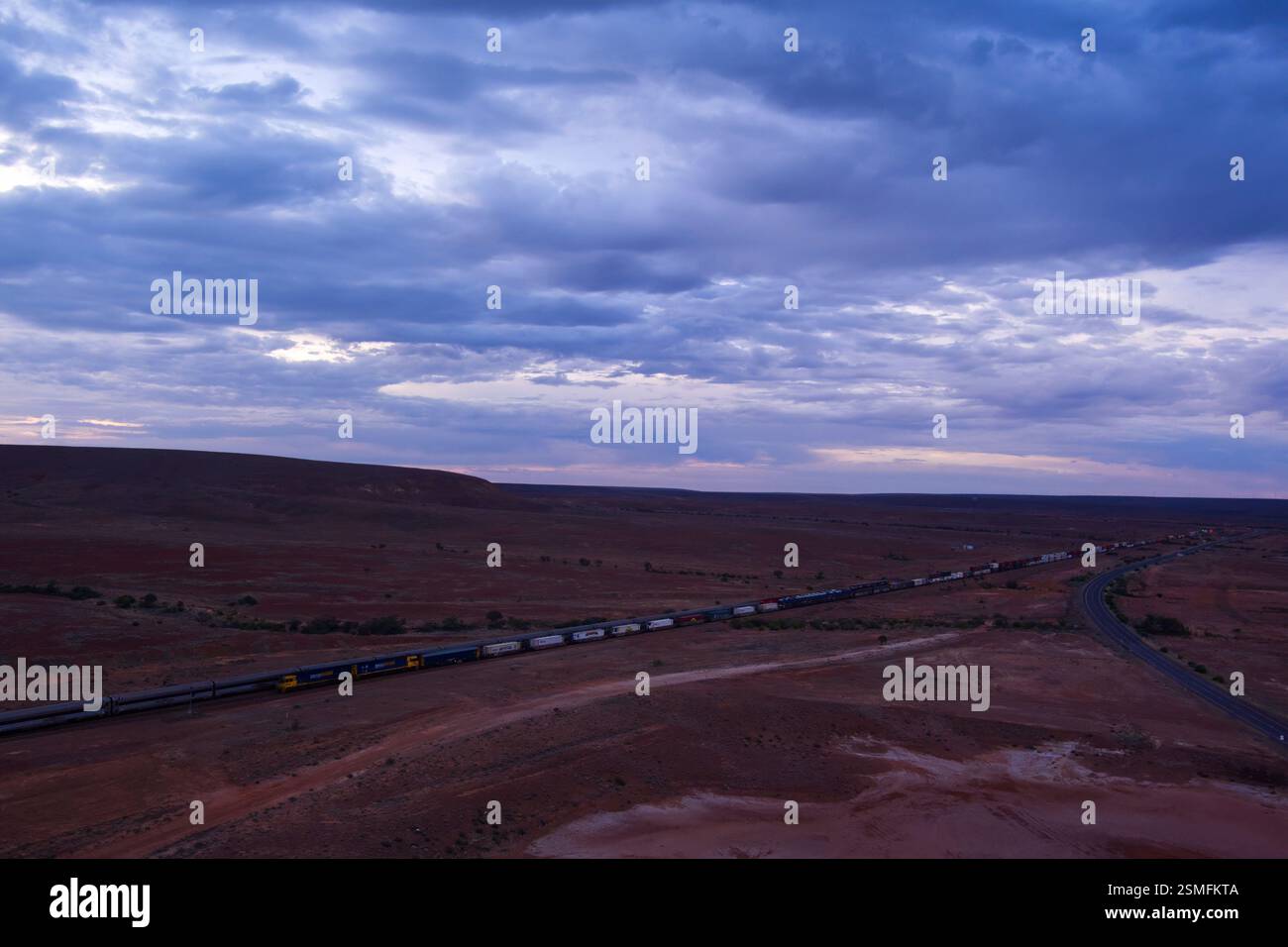 The Ghan passenger train passes a freight train, composed of multiple ...