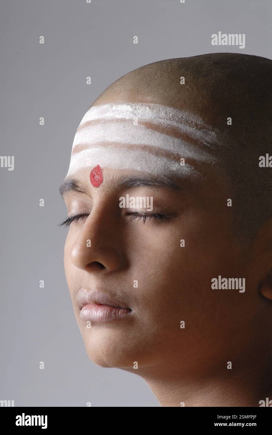 Portrait of South Asian Indian bald boy red tilak on forehead close ...