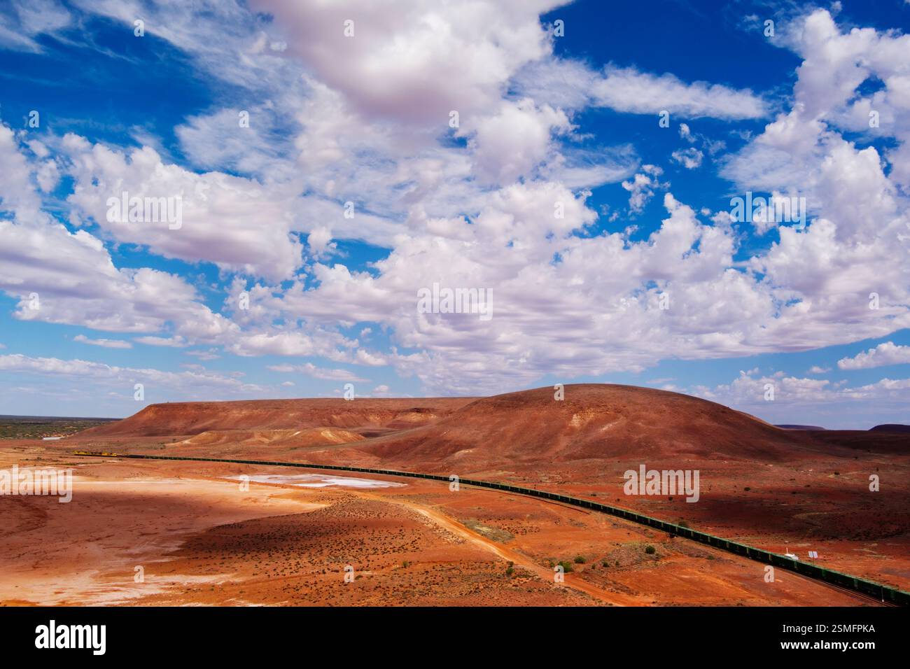 A freight train transporting mineral sands winds through the arid ...