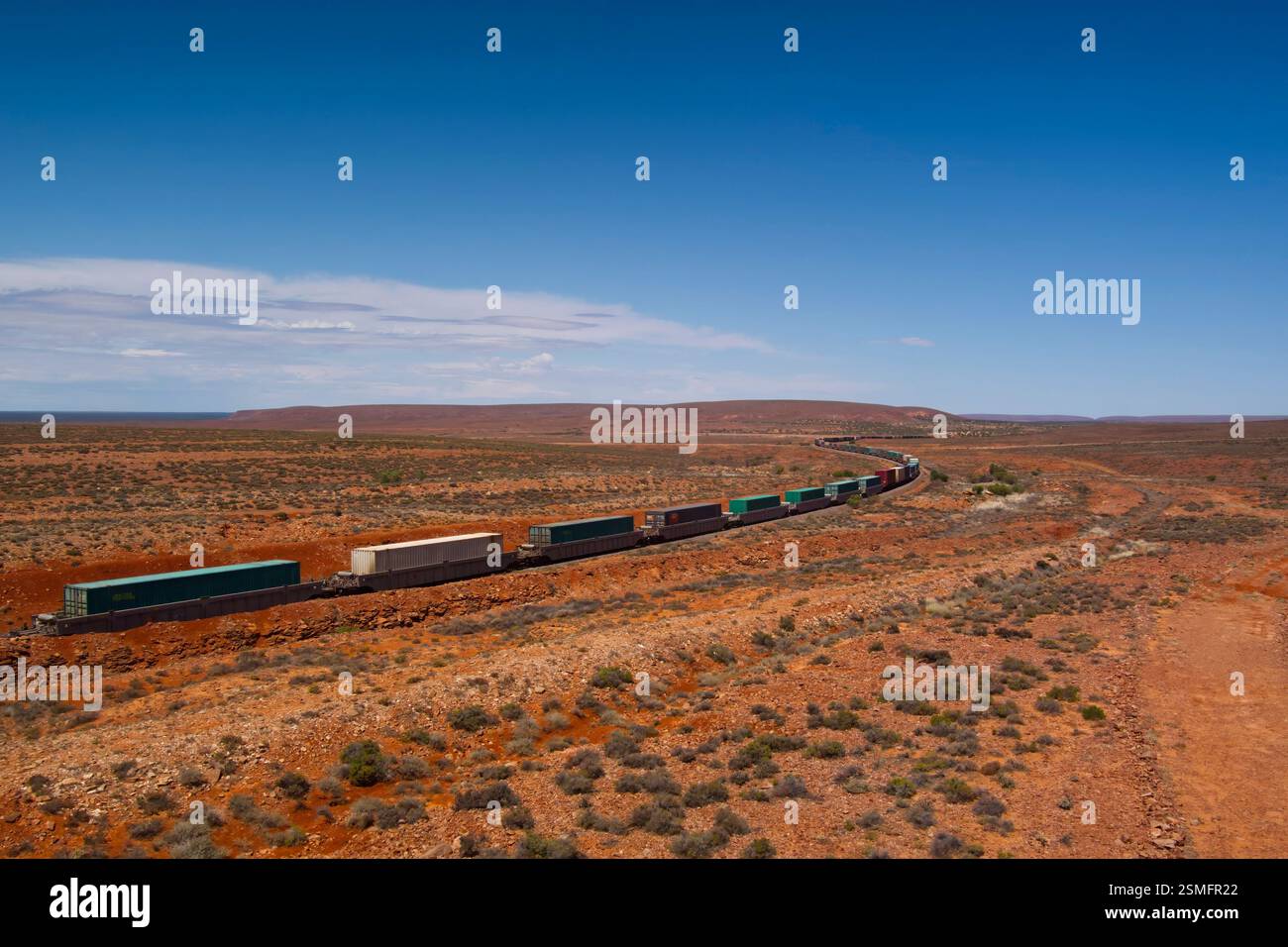 Aerial of Container Freight Train passing through the golden landscape ...