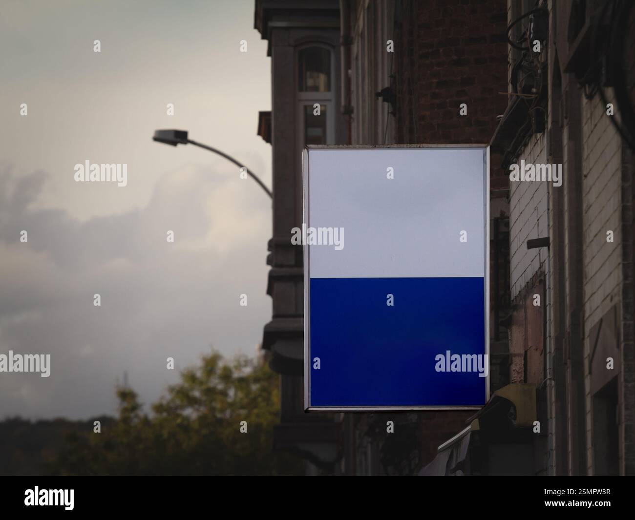 A blank white and blue sign hangs above a storefront, awaiting custom ...