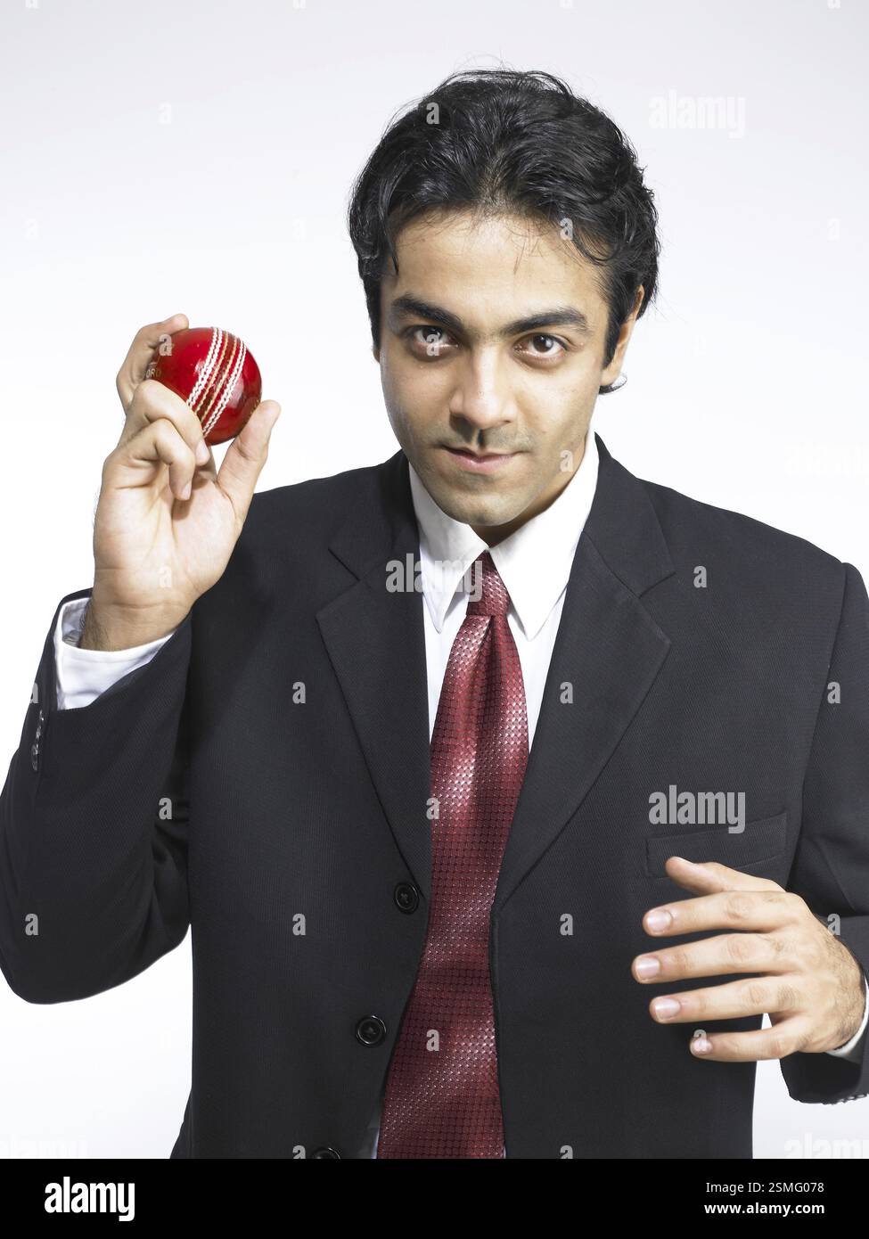 South Asian Indian executive holding and showing maroon colour cricket ...