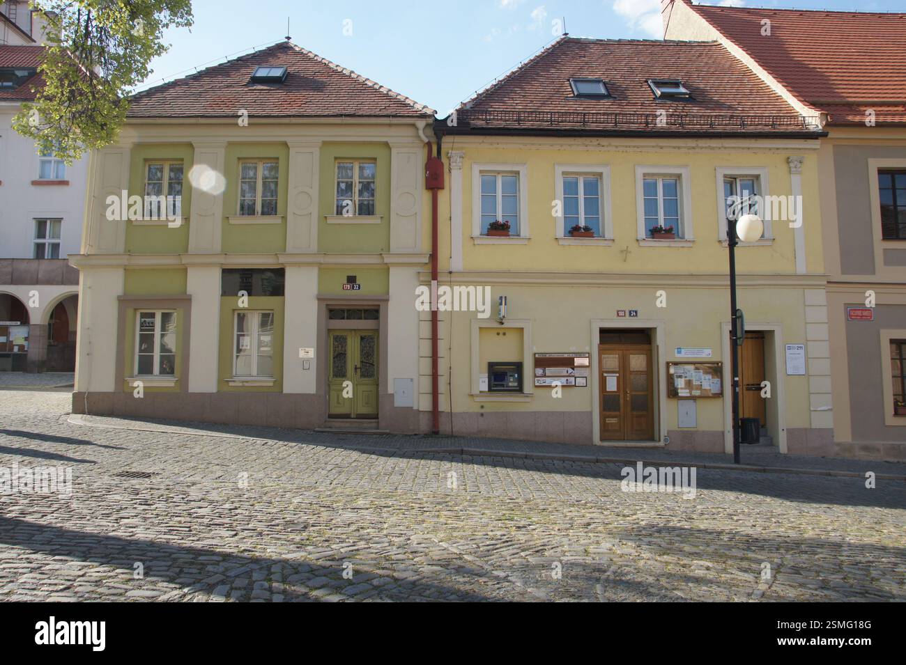 Two colorful buildings, one yellow and one green, stand on a ...