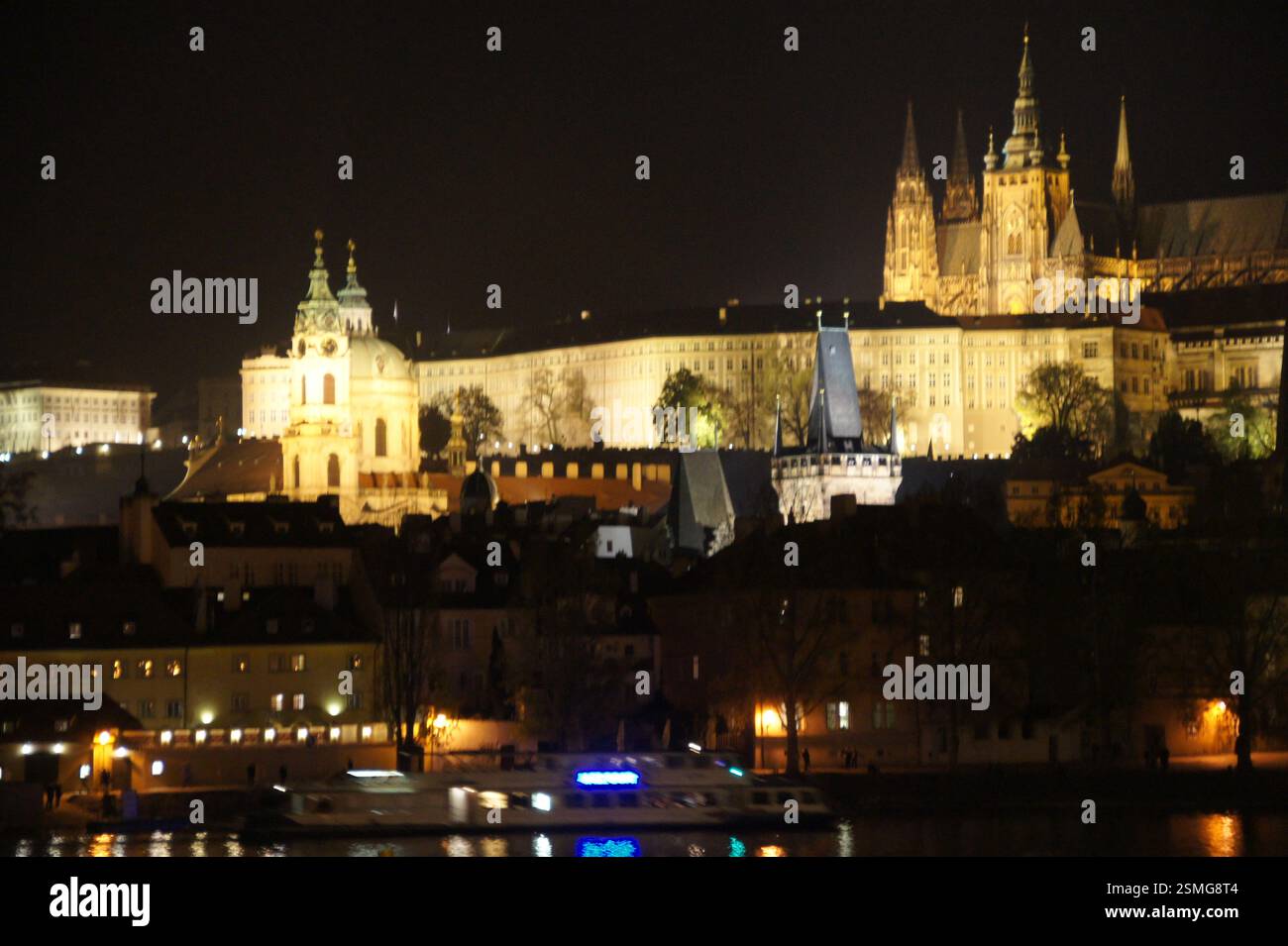 Prague Castle, illuminated spires and walls rise above the Vltava River ...