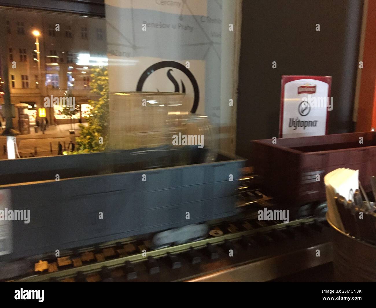 Toy train on bar counter. Chubby glass on a toy train car. Model train ...