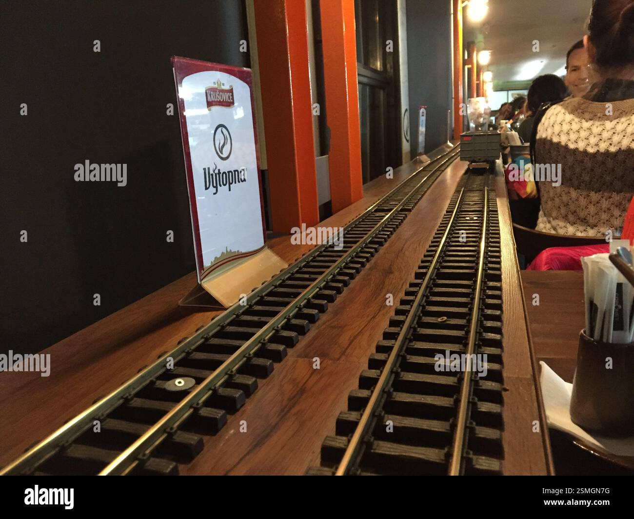 Toy train on bar counter. Chubby glass on a toy train car. Model train ...