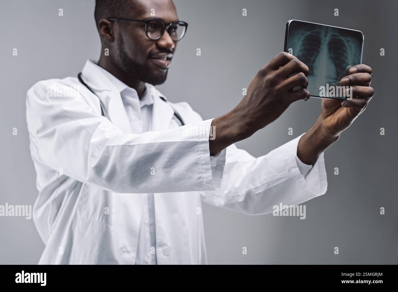 Mid adult doctor examining a chest x-ray in a clinical setting ...
