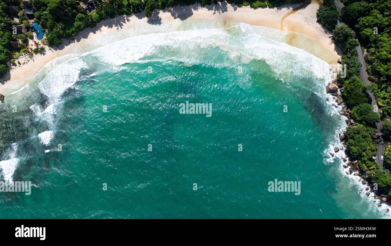 Turquoise waters kiss the beach's sandy shore, surrounded by vibrant ...
