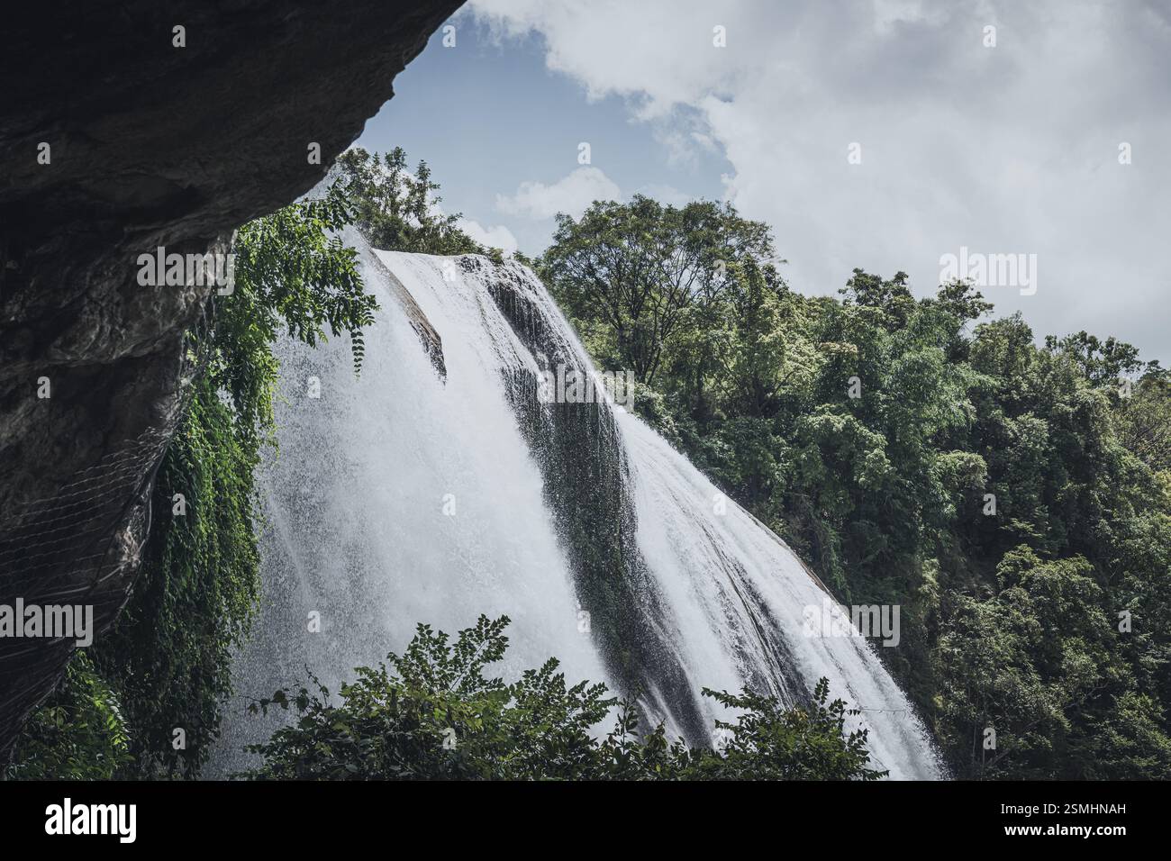 The waterfall interrupts violently the peaceful continuous flow of the ...