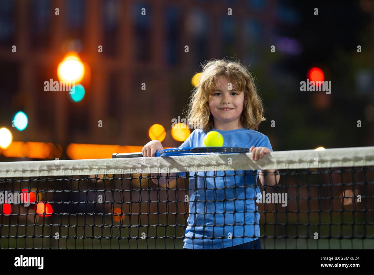 Preteen child swinging racket while training on tennis court at sport ...