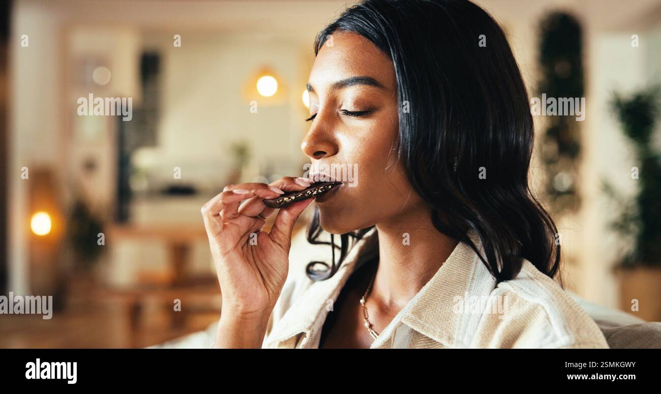 Home, woman and eating chocolate bar, candy and hungry for sugar snack ...