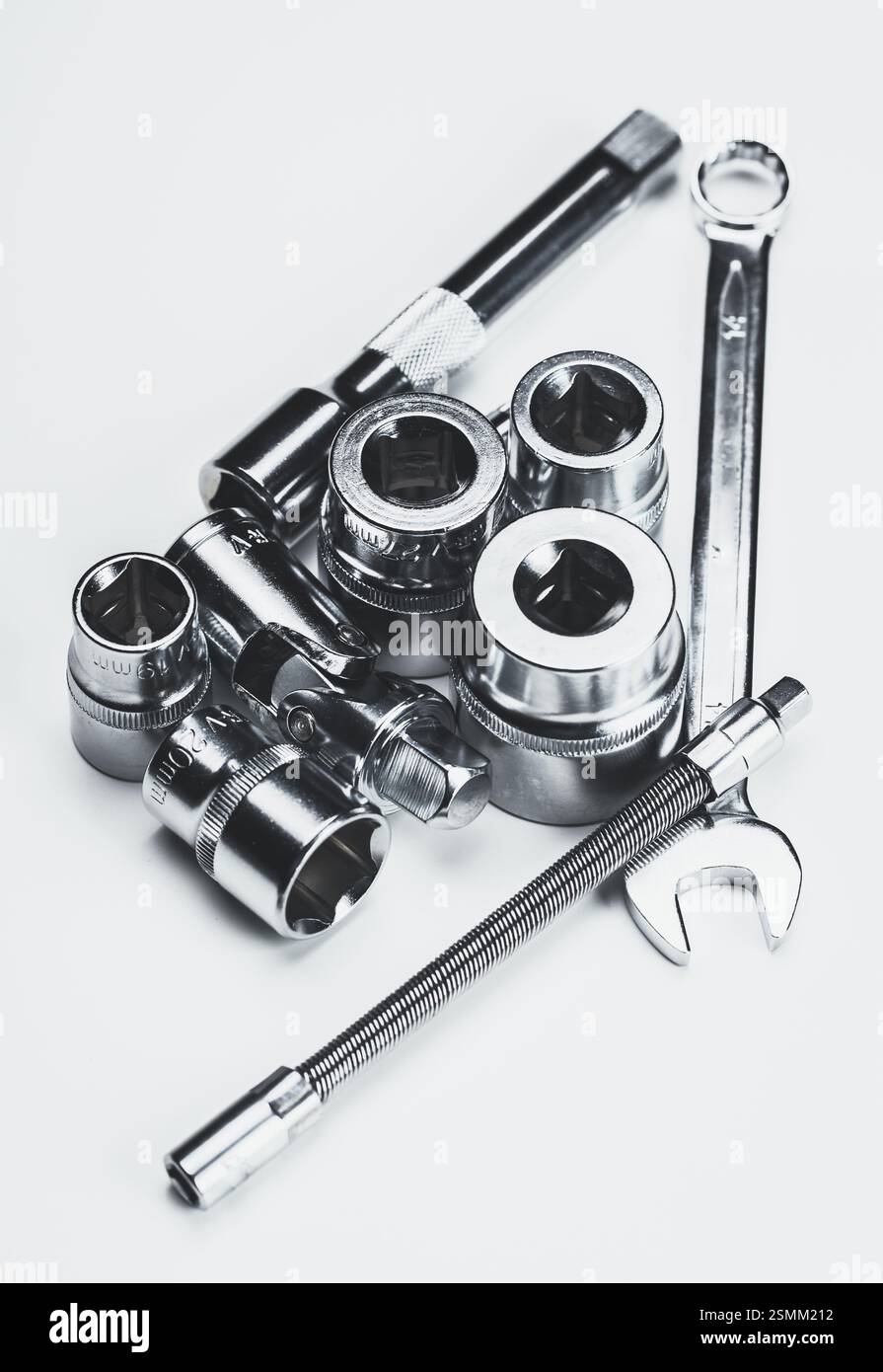 Collection of metallic hand tools arranged on a smooth surface ...