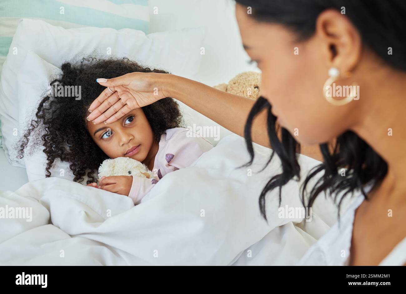 Bedroom, child and sick with hand of mother, support and check temperature for fever at family ...