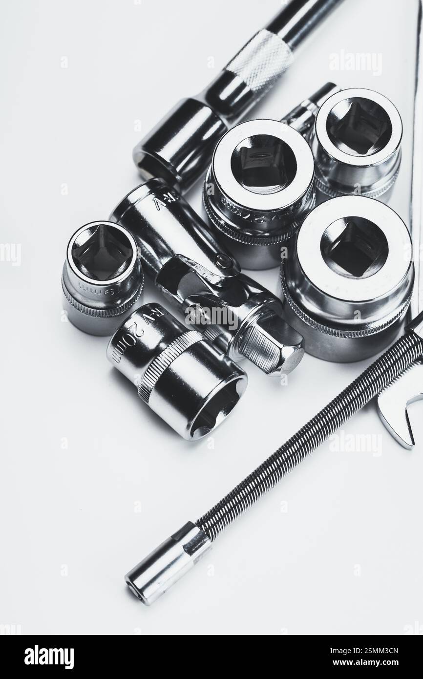 Collection of various metallic tools arranged on a flat surface ...