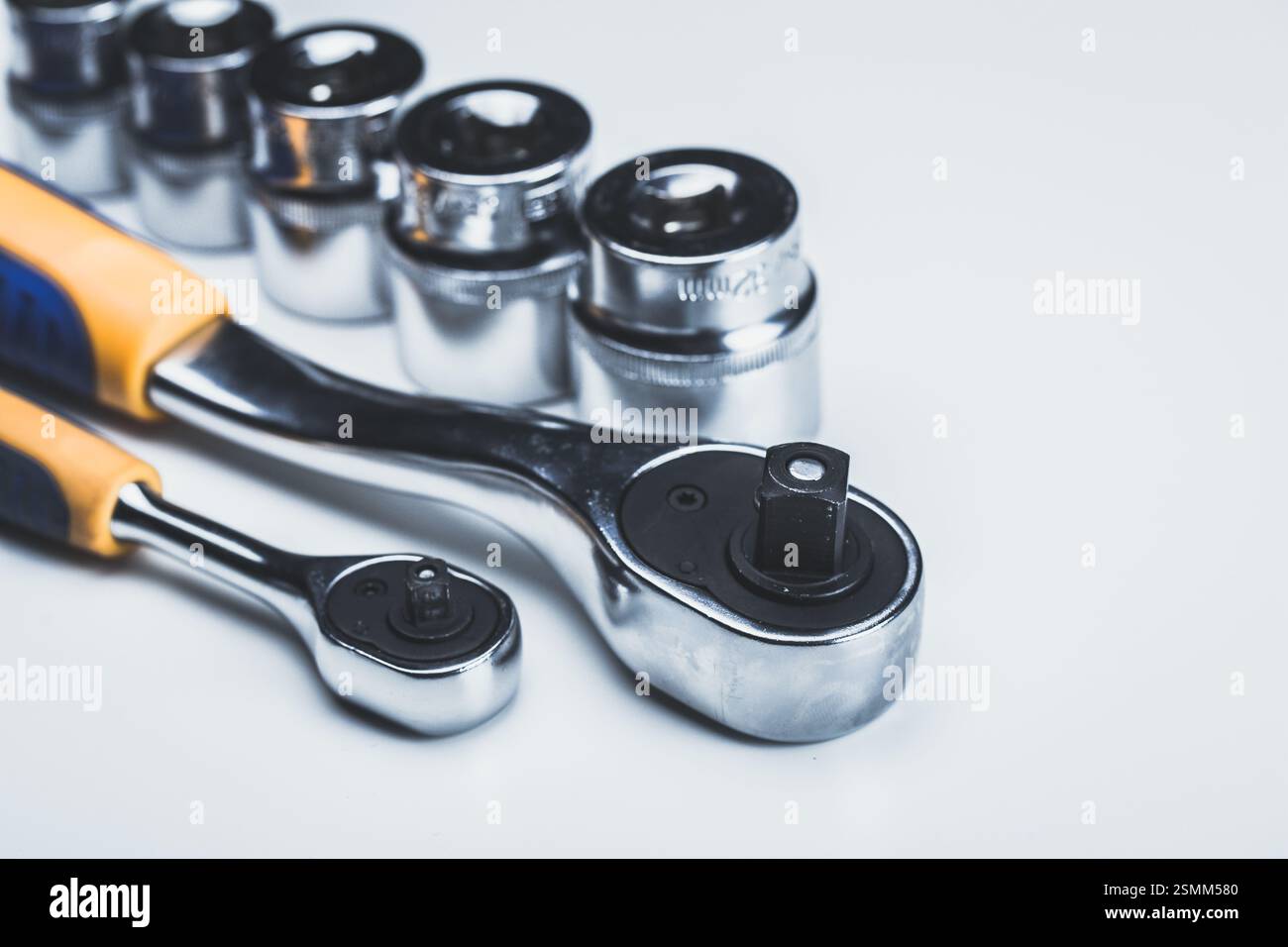 Set of shiny socket wrenches and ratcheting tools displayed on a light ...