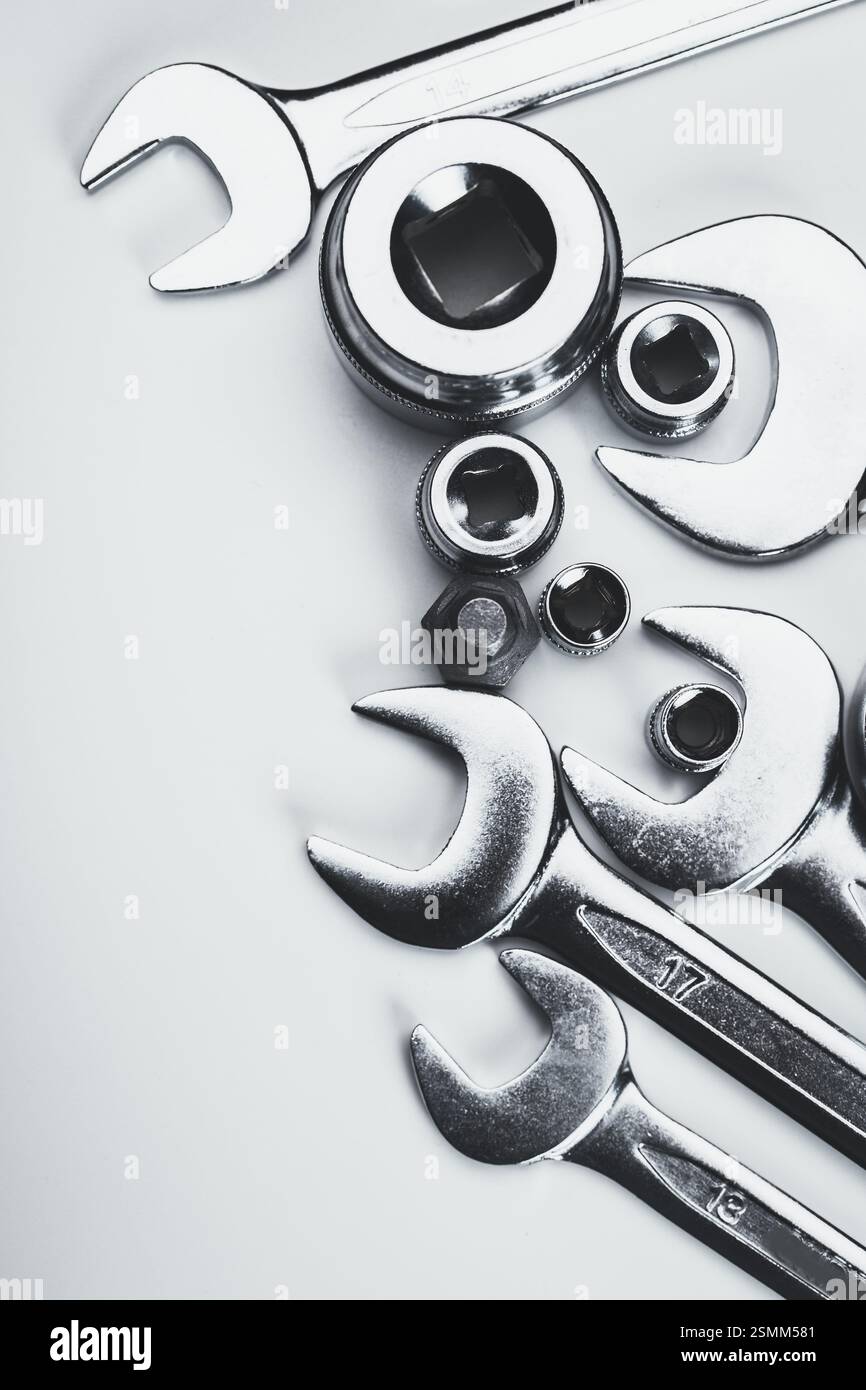 Collection of shiny metallic tools arranged on a light surface ...