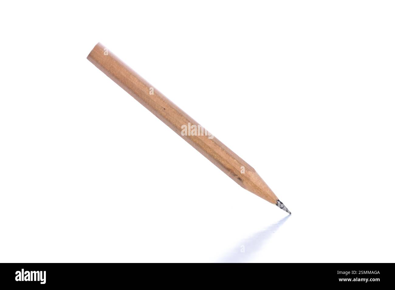 Wooden pencil placed at an angle on a white surface with a sharp point ...