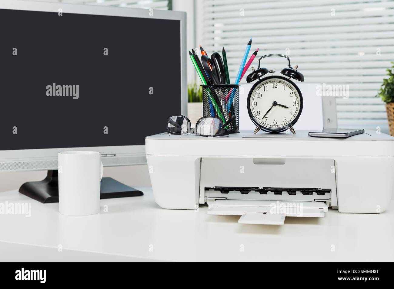 Office workspace featuring printer, clock, stationery, and computer set ...