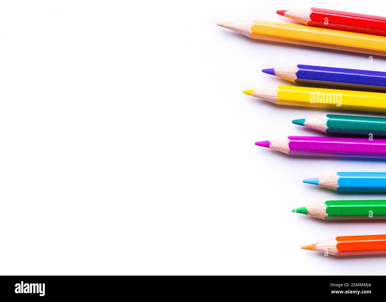 Colorful assortment of sharpened colored pencils arranged on a blank background ready for ...