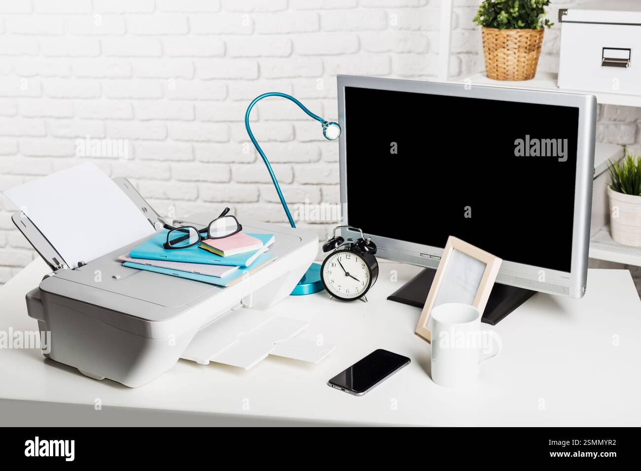 Workstation setup with printer, monitor, and desk accessories in a ...