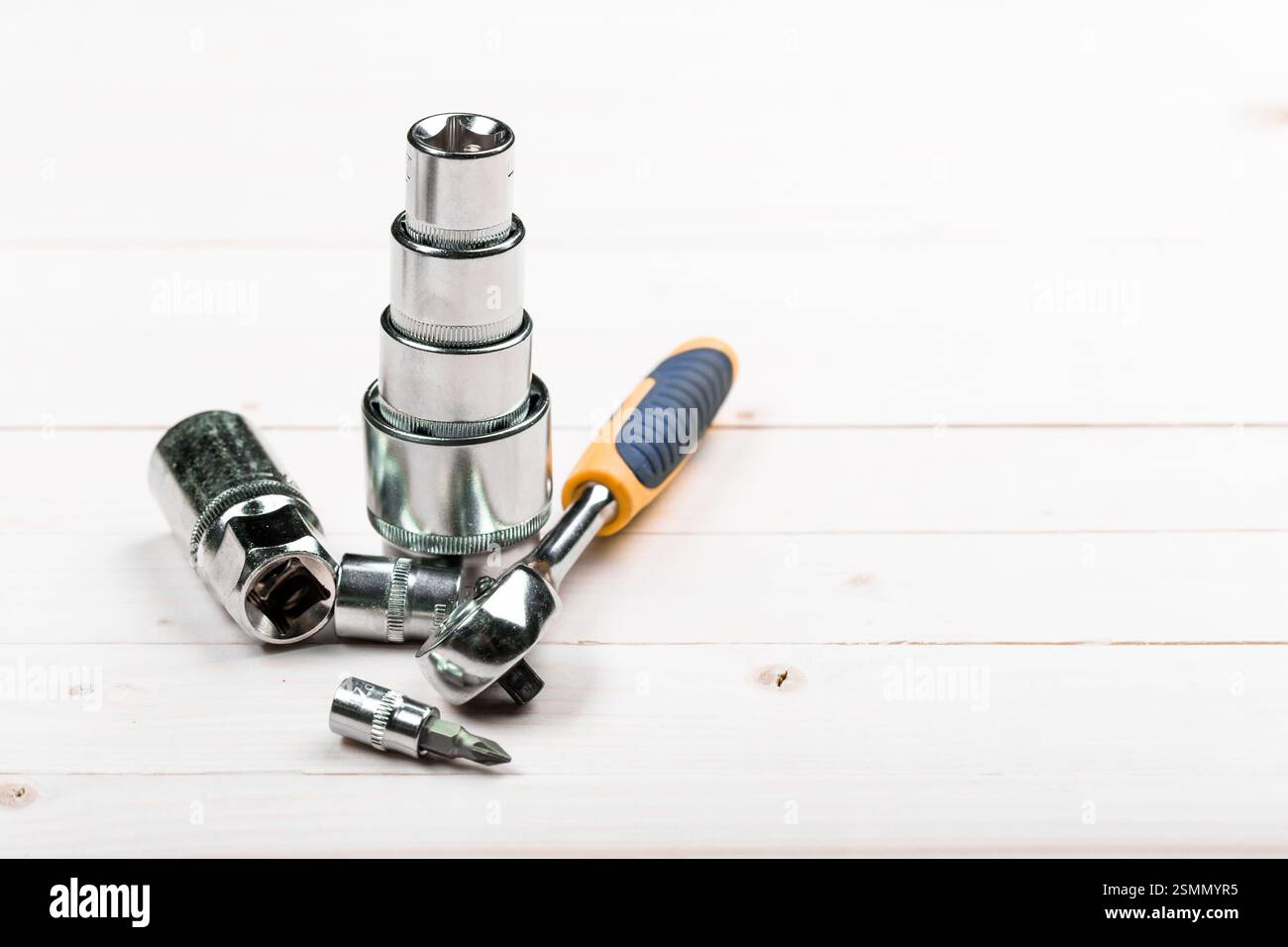 Tools arranged on a workshop table showcasing various sizes of sockets ...