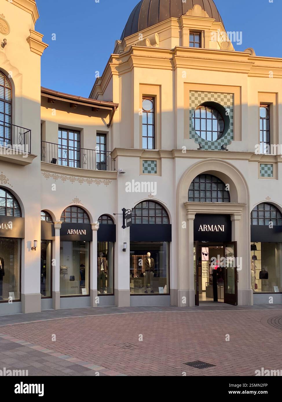 Warm sunlight illuminating Armani storefront at upscale Fidenza Village ...