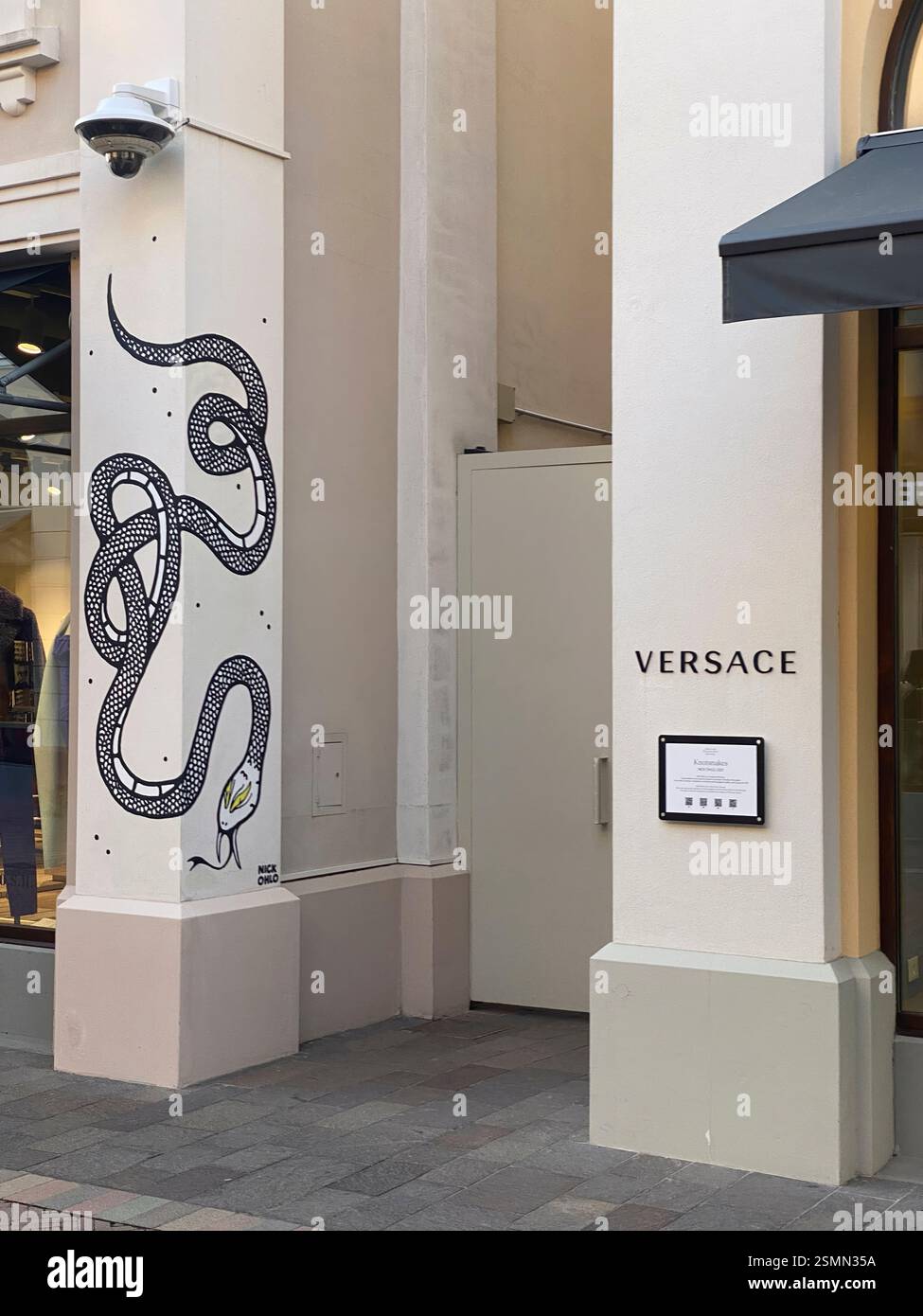 Stylish snake street art brightening a pillar near the Versace store in ...