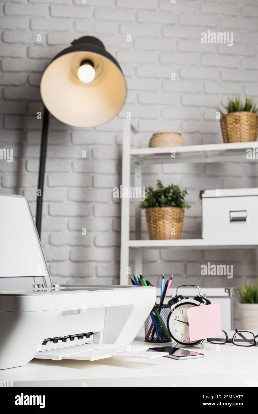 Organized workspace with printer, clock, lamp, and plants in a modern ...